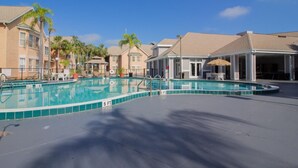 Piscina com marcação de profundidade de 1,5 metros, rodeada por um espaço coberto com área de estar ao ar livre.
