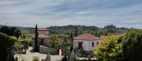 Um pátio com caminhos de pedra, um pequeno jardim e um edifício com telhado vermelho.