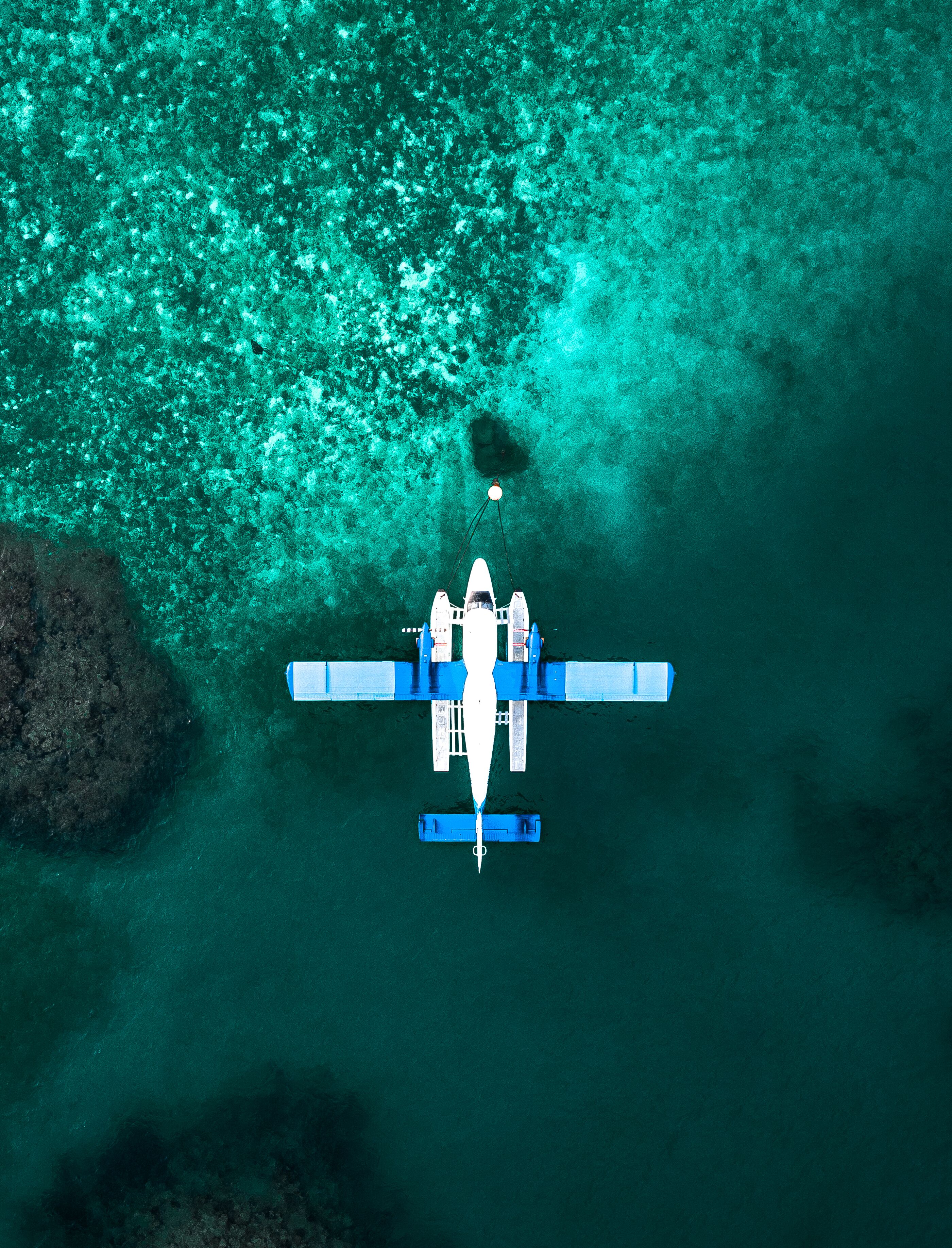 Vista aérea de uma aeronave pequena em um dia claro, com uma costa rochosa ao fundo.