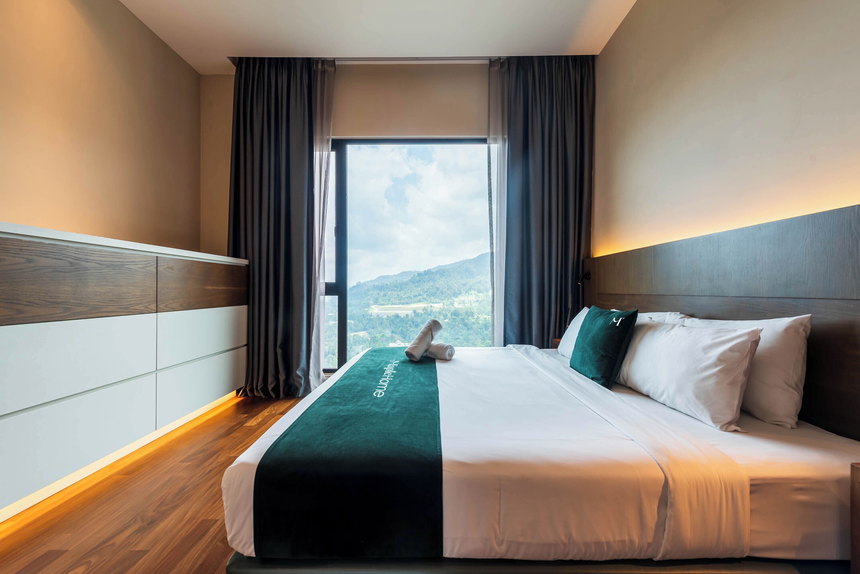 Quarto de hotel com uma cama grande, vista para o exterior e uma janela com cortinas.