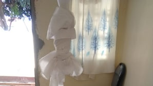 Uma cama com um cobreleito azul escuro e um travesseiro branco.