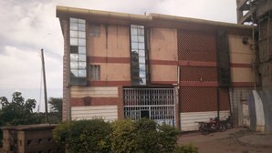 Um edifício de dois andares com uma grande porta de garagem e entrada com grades.