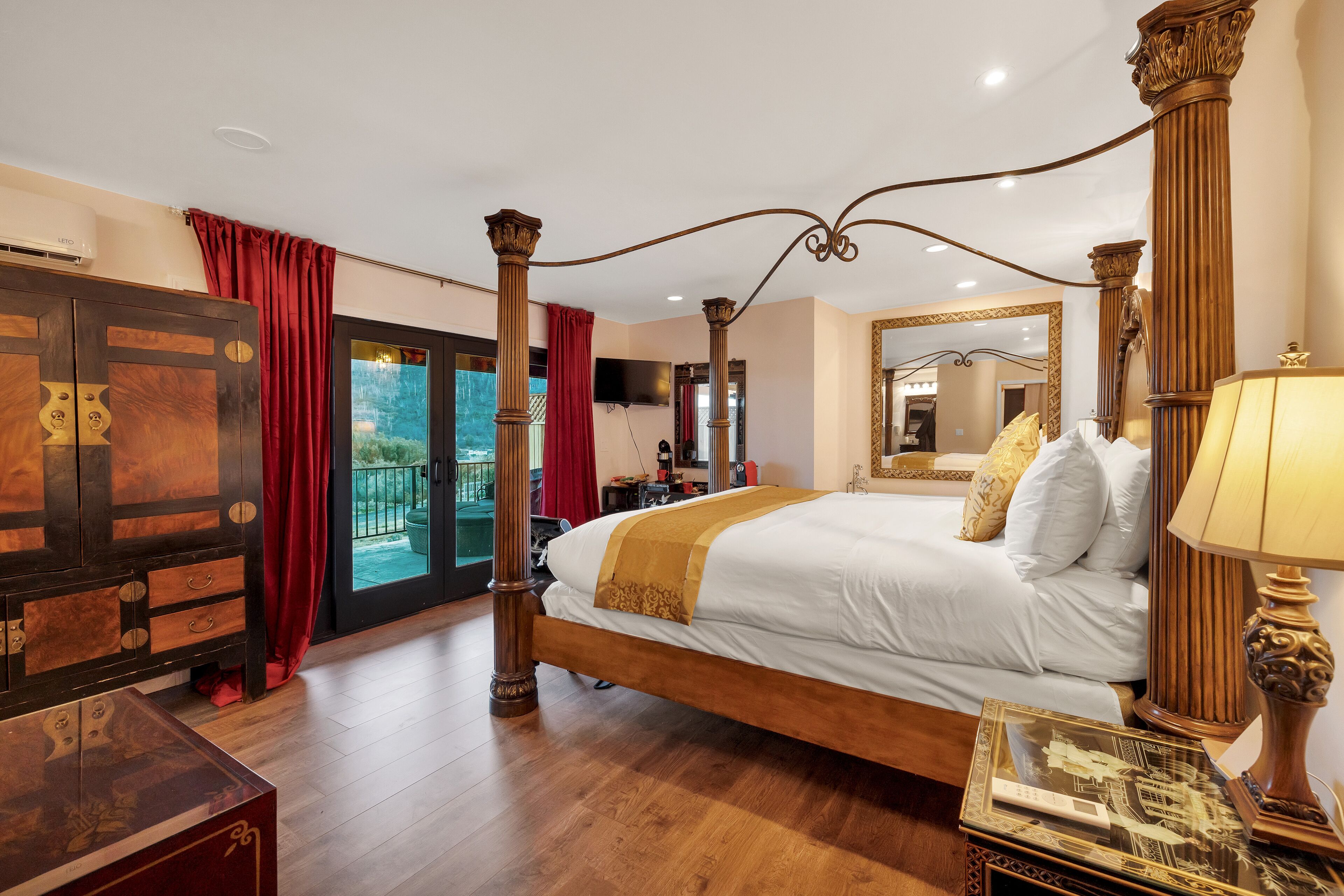 Um quarto espaçoso com uma cama grande, móveis de madeira e vista para a varanda.