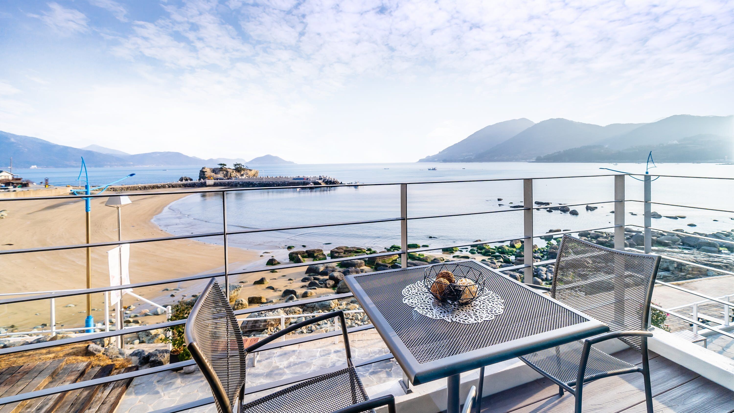 Uma varanda com vista para a praia e o mar.