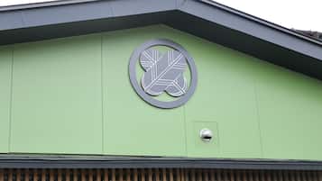 Um edifício com fachada verde e um logotipo circular na parede.