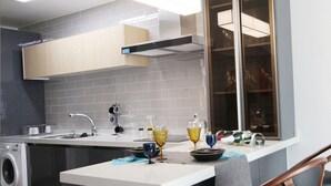 Uma cozinha moderna com forno embutido, pia e janela com vista para a cidade.