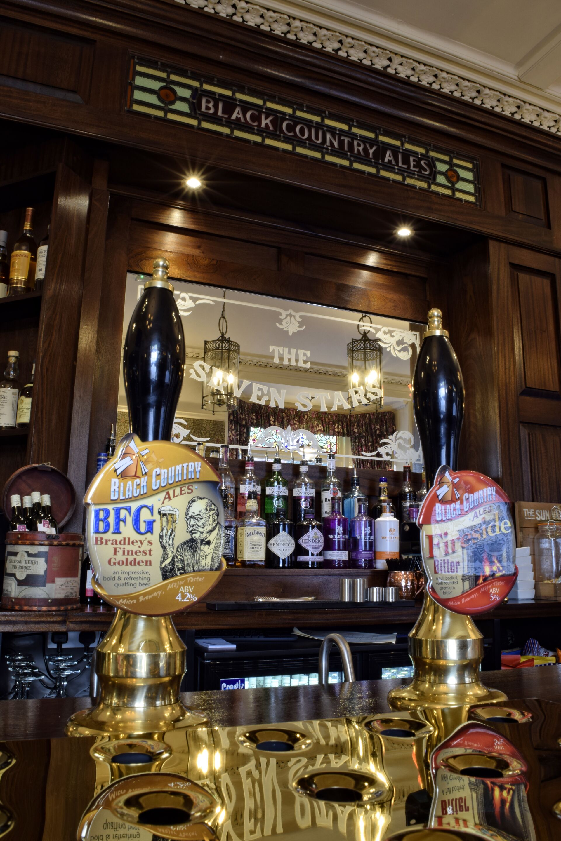 Um balcão de bar com duas torneiras identificadas como 'Black Country Ales' e 'Bradley's Finest Golden Ale'.
