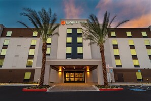 Entrada de hotel com design moderno, destacando uma placa grande para Candlewood Suites.