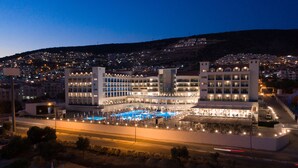 Um hotel com vários andares, piscina e áreas de estar ao ar livre.