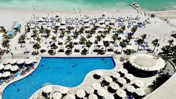 Praia particular, areia branca, espreguiçadeiras, guarda-sóis
