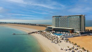 Um hotel moderno com piscina e acesso à praia.