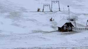 Pista de esqui coberta de neve, com teleféricos e um chalé pequeno.