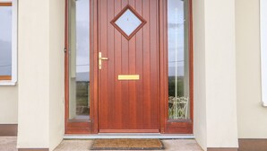 Uma porta de madeira com painel de vidro e puxador de latão.