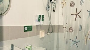 Casa de banho com sanita, lavatório e chuveiro.