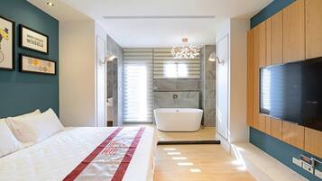 Quarto de hotel moderno com uma cama grande, televisão de tela plana, banheira e vista para a cidade.