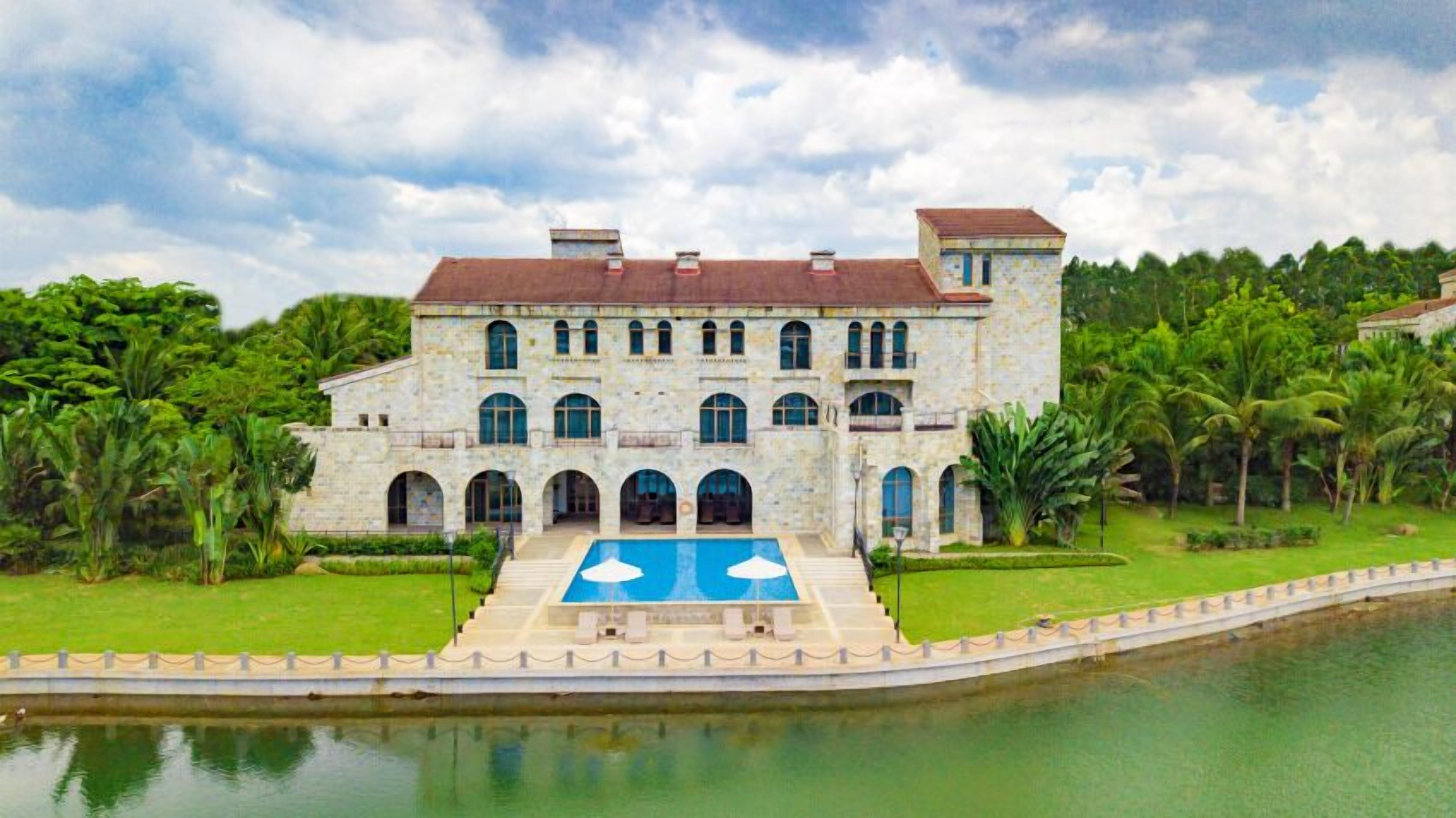 Um edifício de pedra grande com um pátio central e uma piscina.
