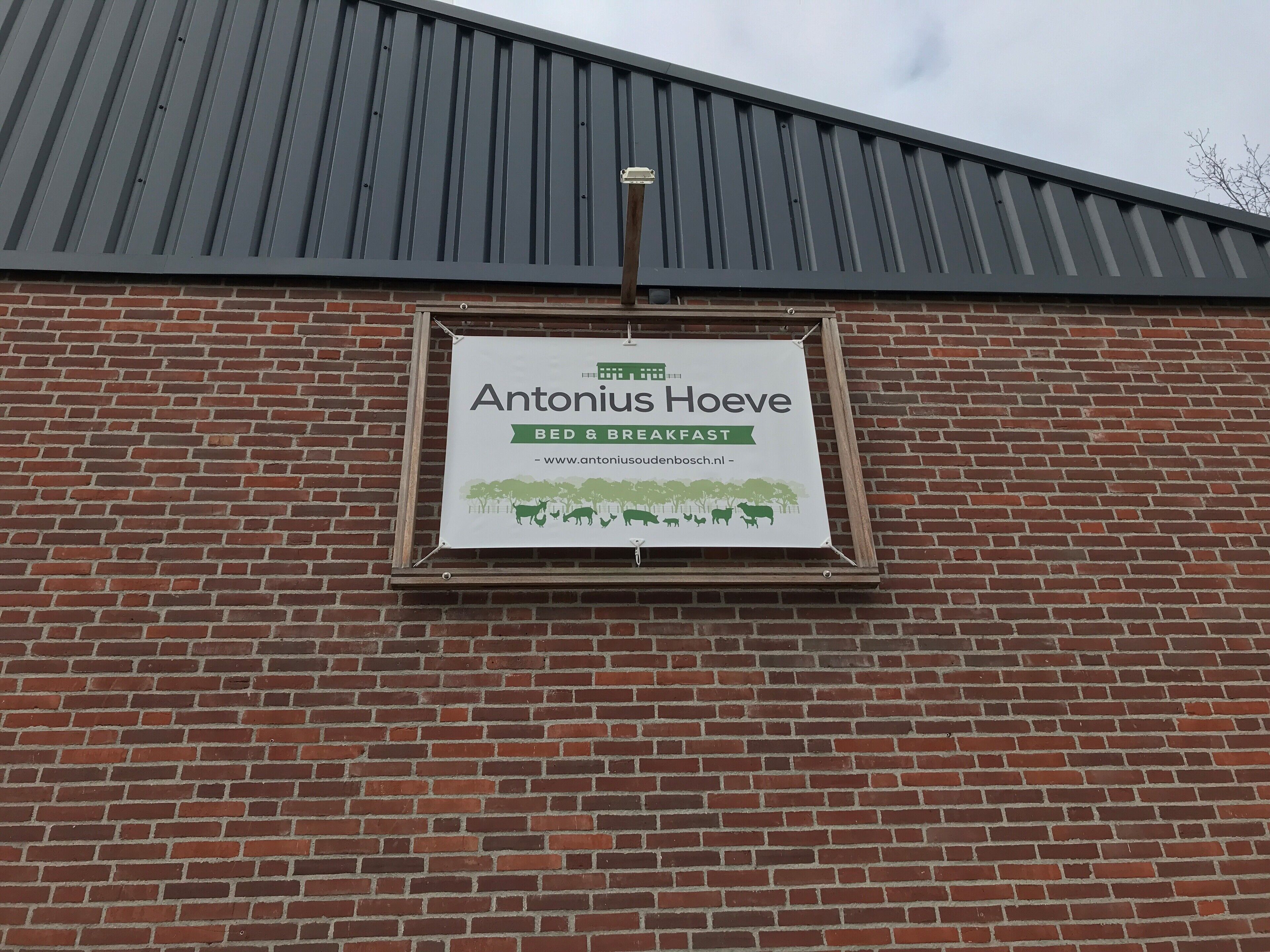 Placa para Antonius Hoeve Bed & Breakfast, com parede de tijolos e telhado de metal.