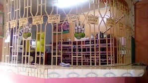 Uma área de bar com várias prateleiras cheias de garrafas, identificadas como 'Scottish Leader'.