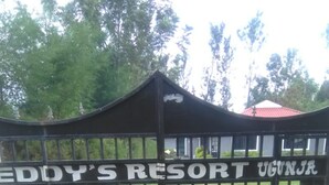 Um portão de metal preto com a inscrição 'EDDY'S RESORT UGANJA'.