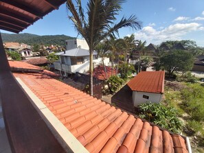 Zona residencial com telhados em terracota, palmeiras e casas com estilos arquitetônicos diversos.