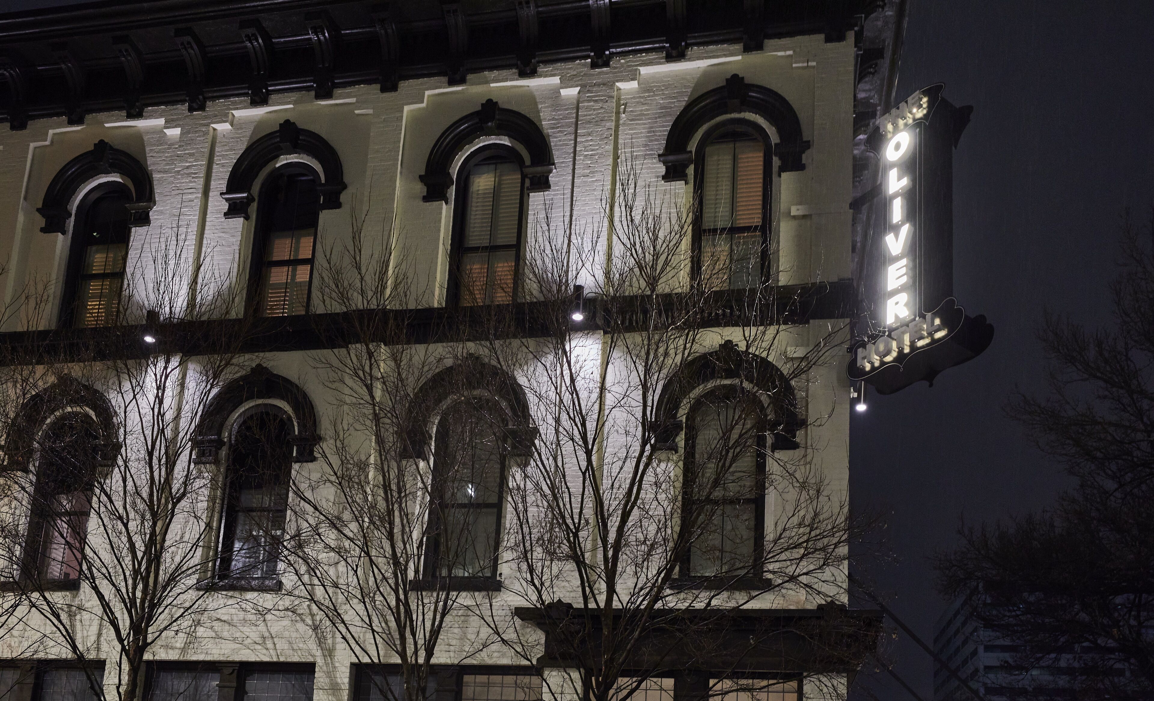Um edifício histórico com várias janelas em arco e uma placa visível indicando ser um hotel.