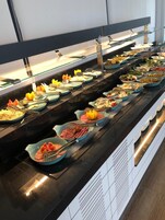 Buffet com diversos alimentos e utensílios.