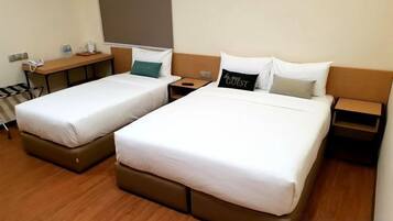 Quarto de hotel com duas camas, uma escrivaninha e uma cadeira.