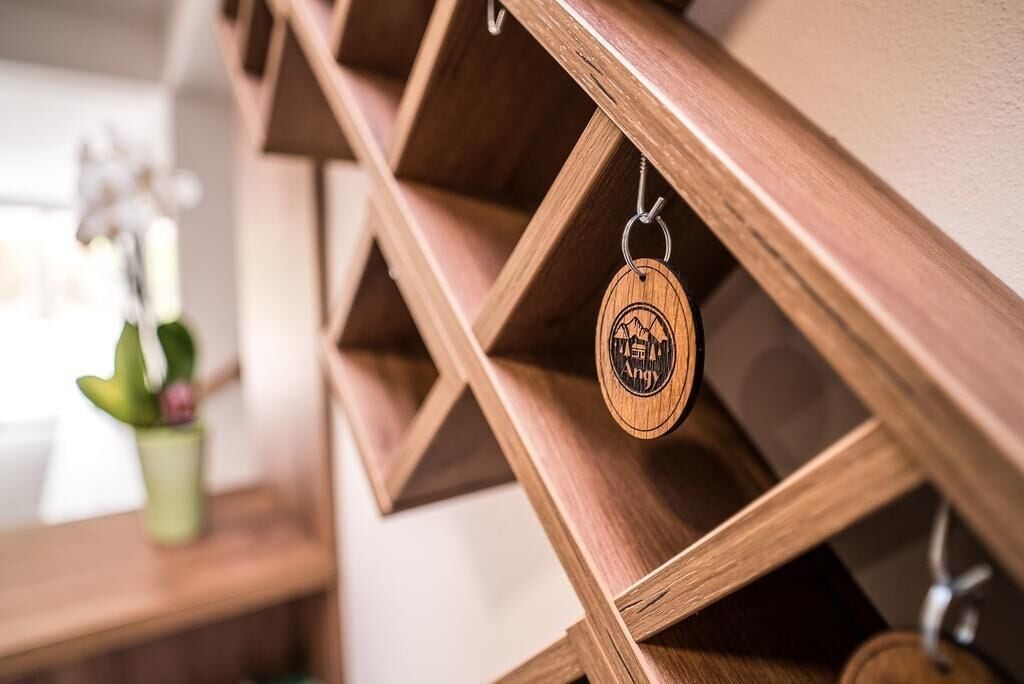 Uma estante de madeira para vinhos com um chaveiro pendurado.
