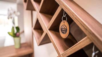 Uma estante de madeira para vinhos com um chaveiro pendurado.