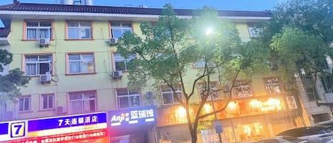 Um edifício com várias fachadas, incluindo uma farmácia e um restaurante.