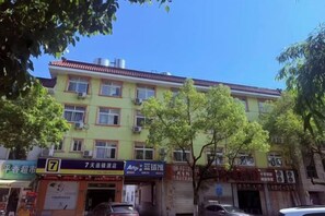 Um edifício de vários andares com diversas lojas no térreo, incluindo uma farmácia e um restaurante.