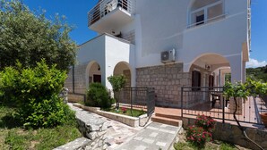 Um edifício de dois andares com fachada de pedra, arcadas e varanda.
