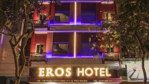 Um hotel com uma placa indicando "EROS HOTEL" e o endereço visível.