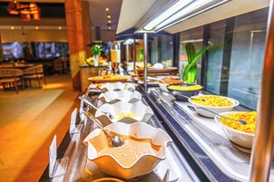 Uma mesa de buffet com diversos alimentos e utensílios.