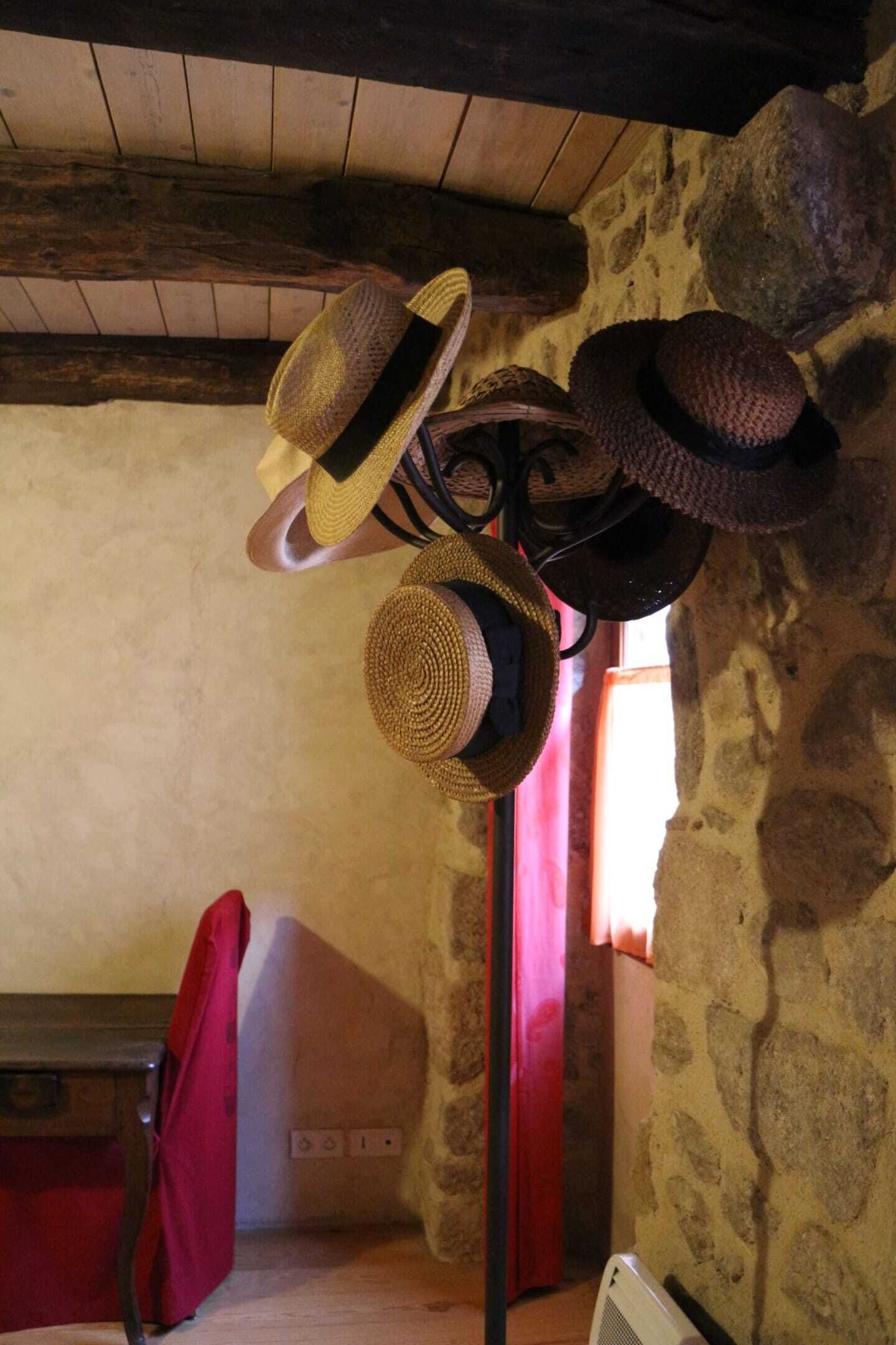 Quarto rústico com parede de pedra, teto de madeira e uma cadeira vermelha.