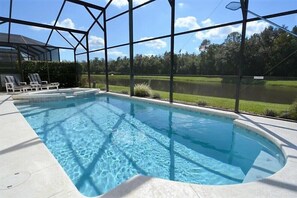 Piscina com vista ampla da paisagem ao redor, incluindo um lago e árvores.