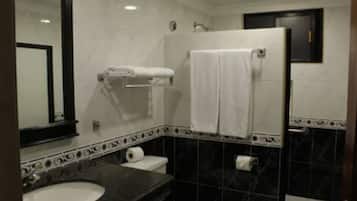 Uma casa de banho com lavatório, sanita e zona de duche.