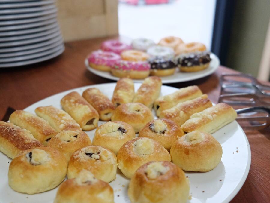 Um prato com pastéis recém-assados sobre uma mesa de madeira.