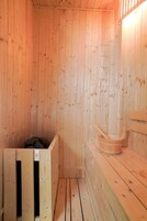 Uma sauna de madeira com um banco e um balde.