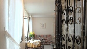 Quarto com área de jantar, incluindo mesa, cadeiras, radiador e portão de metal decorativo.