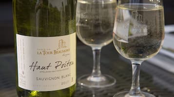 Uma garrafa de vinho Haut Poitou e dois copos sobre uma mesa.