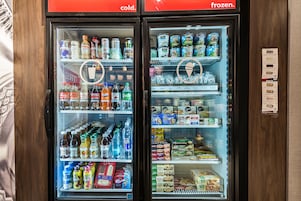 Duas máquinas de venda automática com diversas bebidas e lanches.