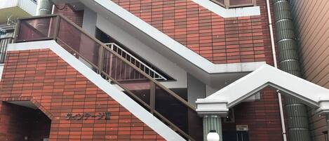 Um edifício de tijolos vermelhos com uma escadaria que leva a um andar superior.