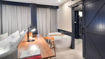 Uma casa de banho moderna com uma banheira, uma mesa de madeira e uma cadeira.