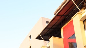 Um edifício de vários andares com uma faixa vermelha vertical e uma placa que diz 'Sleves'.