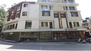 Um edifício de vários andares com lojas no térreo e apartamentos nos andares superiores.