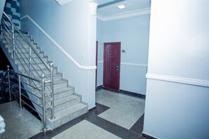 Uma escadaria com corrimãos de metal que dá para um patamar.