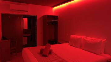 Quarto de hotel com uma cama, um guarda-roupa e uma escrivaninha.