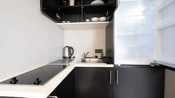 Um frigorífico, uma placa de cozinha, utensílios de cozinha