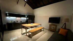 Espaço compacto com cozinha, área de refeições e espaço para sentar.